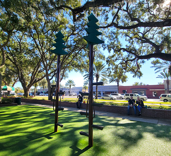 Whimsical tree sculptures add artistic flair to the landscape, proving that even playground equipment can double as environmental art in this thoughtfully designed space.