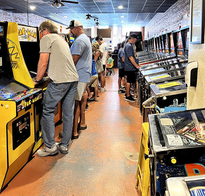 The communal spirit of gaming shines as players stand shoulder to shoulder, sharing tips and friendly competition across generations.