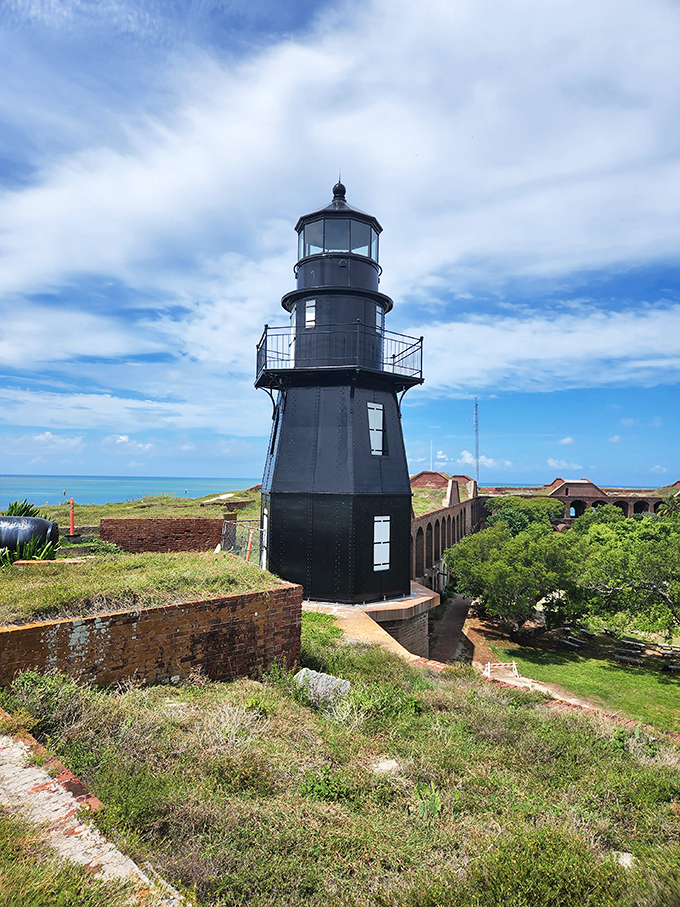 Garden Key Light's black tower creates a striking contrast against the historic brick walls of Fort Jefferson, a unique lighthouse experience in a fortress setting.