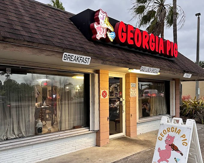 The humble exterior of Georgia Pig BBQ features the restaurant's name in bold letters, with "BREAKFAST" prominently displayed for early risers.