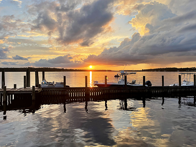 Sunset transforms the dock into nature's theater, with boats silhouetted against a sky painted in impossible colors.