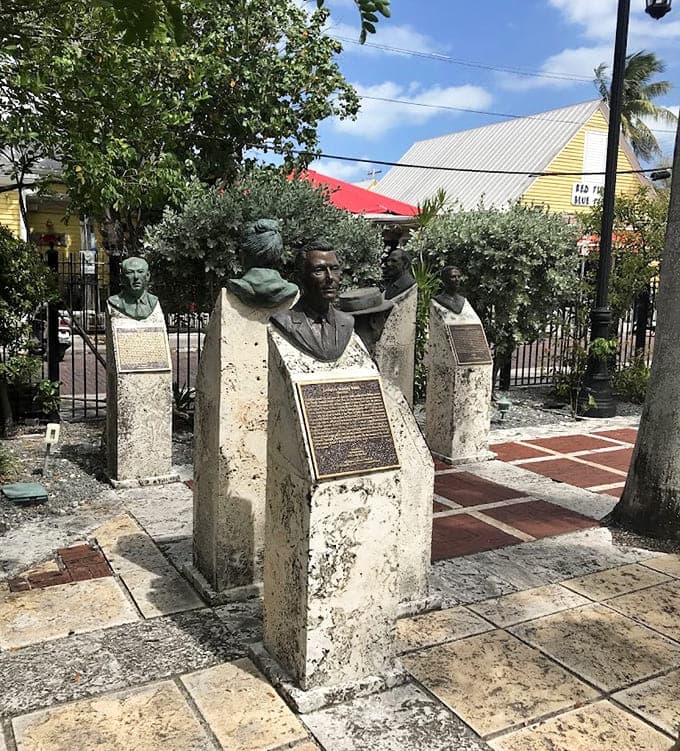 Bronze heads emerge from weathered pillars like the island's memory made solid, each face holding stories worth hearing over coffee.