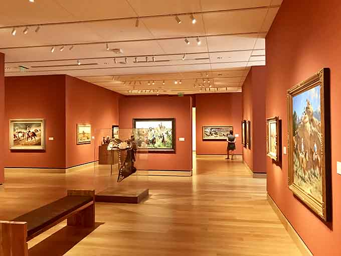 The warm terracotta walls create the perfect backdrop for Western art, like sunset colors brought indoors.