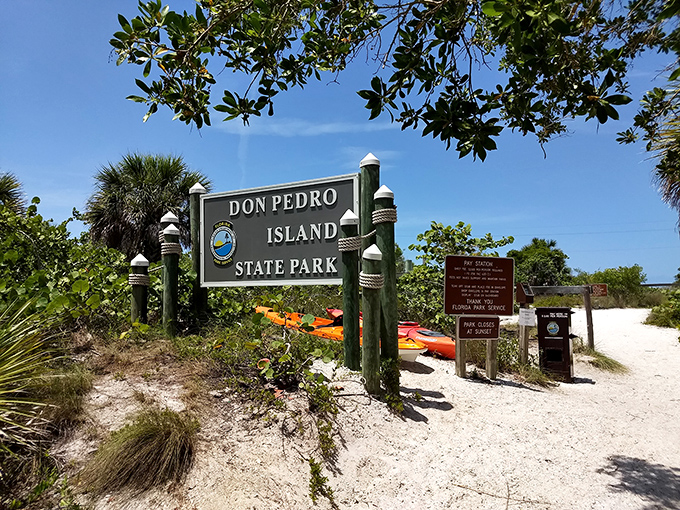 The official welcome: Don Pedro Island State Park's entrance sign stands sentinel, with colorful kayaks waiting to transport adventurers.