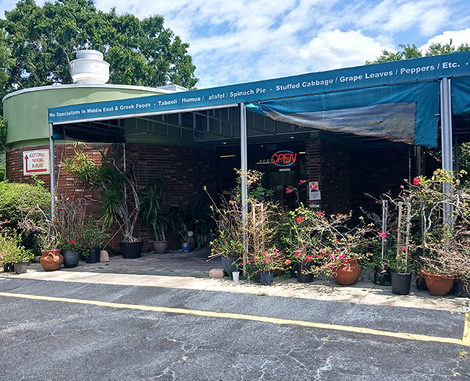Bread & Butter's lush garden setting creates a Mediterranean oasis. The awning advertises specialties like tabouleh, hummus, and stuffed grape leaves.