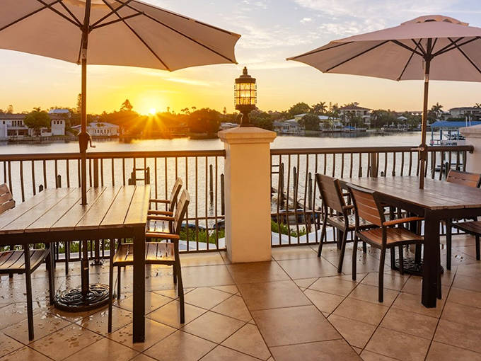 Castile's waterfront terrace captures golden hour magic. Wooden tables and comfortable chairs invite lingering over Spanish-inspired seafood dishes.