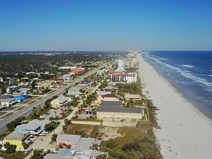 The town's beachfront features colorful buildings and palm-lined streets just steps from the famous drivable beaches.
