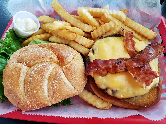 A burger that requires jaw exercises before attempting, with bacon standing at attention and cheese melting down the sides like delicious lava.