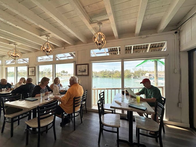 Windows framing water views like living paintings &ndash; Pop's dining room brings the outside in while keeping the AC cranking. Florida perfection.