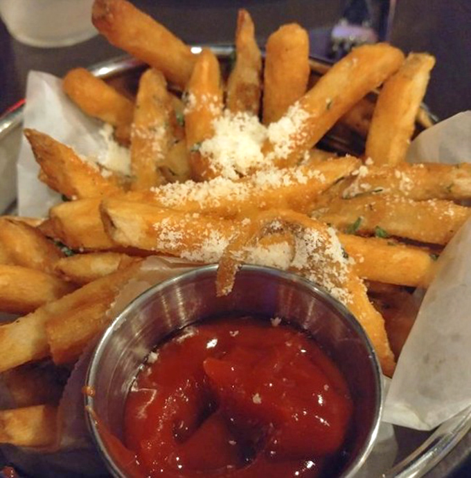 Golden fries dusted with parmesan and served with ketchup &ndash; proof that even the humblest potato can achieve greatness with the right treatment.