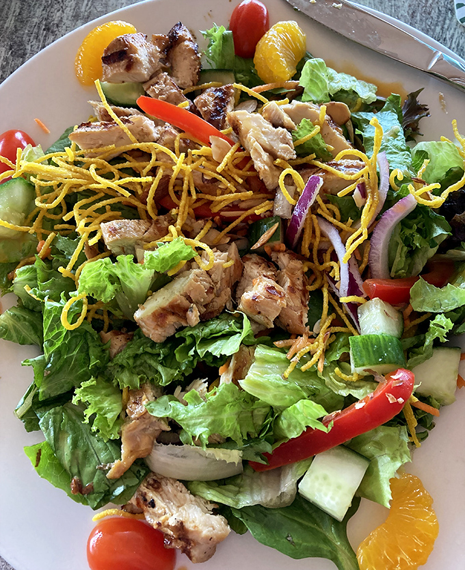 Grilled chicken atop crisp greens with mandarin oranges and crunchy toppings – a lighter option that doesn't sacrifice flavor.