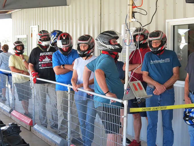 The anticipation is palpable as these helmeted warriors await their turn to conquer the track, each mentally rehearsing their racing lines.