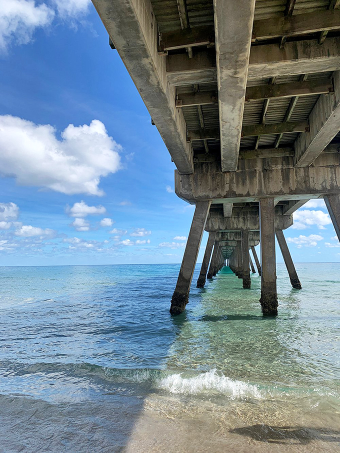 Beneath the boardwalk reveals the architectural poetry of the pier&mdash;concrete geometry meeting crystal waters in perfect harmony.