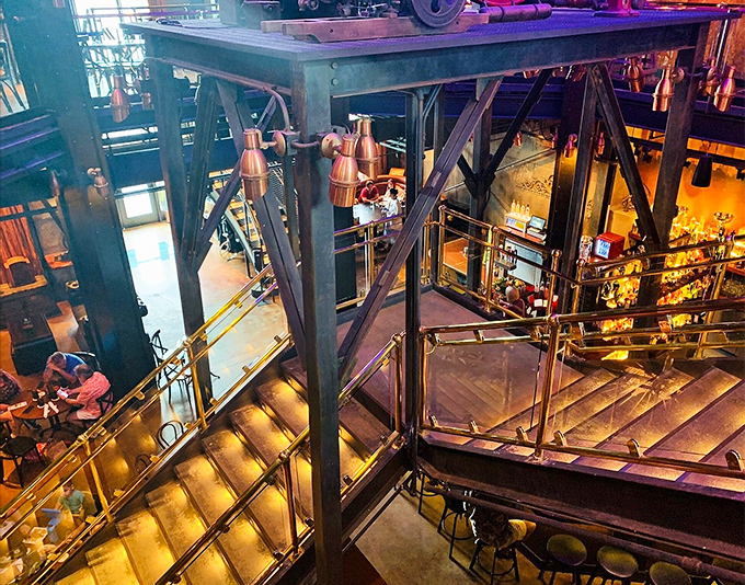 The multi-level layout invites exploration, with industrial catwalks and staircases leading guests through this mechanical wonderland of dining spaces.