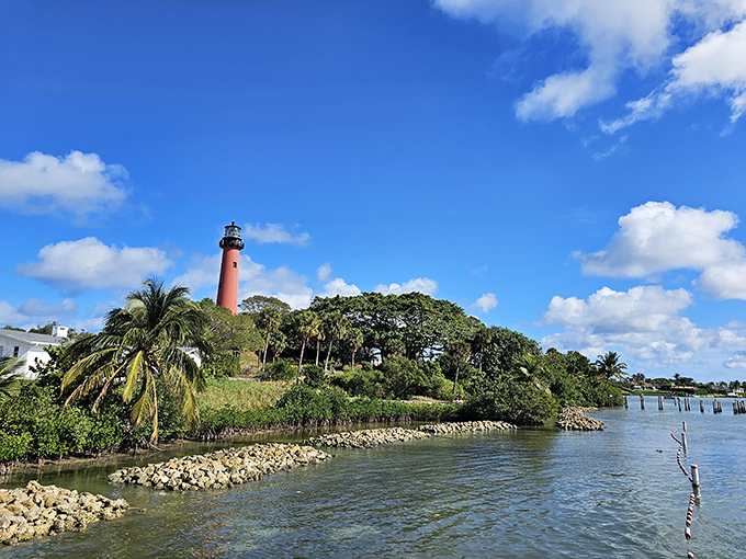 Jupiter Inlet Lighthouse's vibrant red tower stands out dramatically against the blue sky, a colorful beacon that's become an icon of Florida's east coast.
