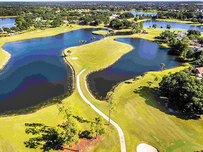 Winding paths between blue ponds and emerald fairways create an artistic landscape where nature and recreation blend seamlessly together beautifully.