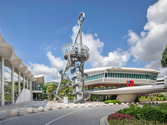 A futuristic silver tower spirals skyward at Aventura Mall, where adults rediscover their inner child through the thrill of gravity-powered descent.