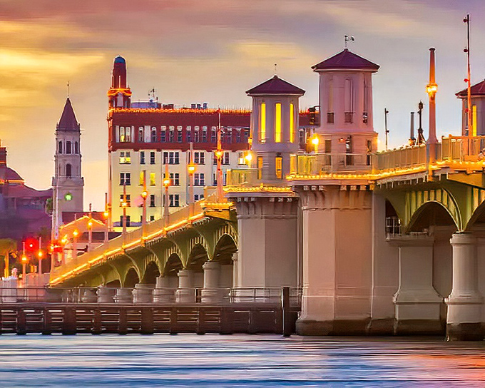 The Bridge of Lions glows at sunset, its arches creating a golden gateway between past and present in St. Augustine's historic harbor.