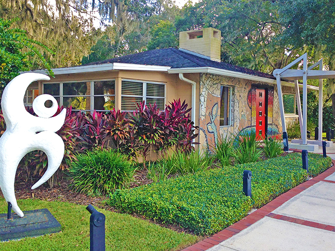 The Casselberry Art House welcomes visitors with its charming cottage exterior, where vibrant sculptures and lush landscaping create an artistic first impression.