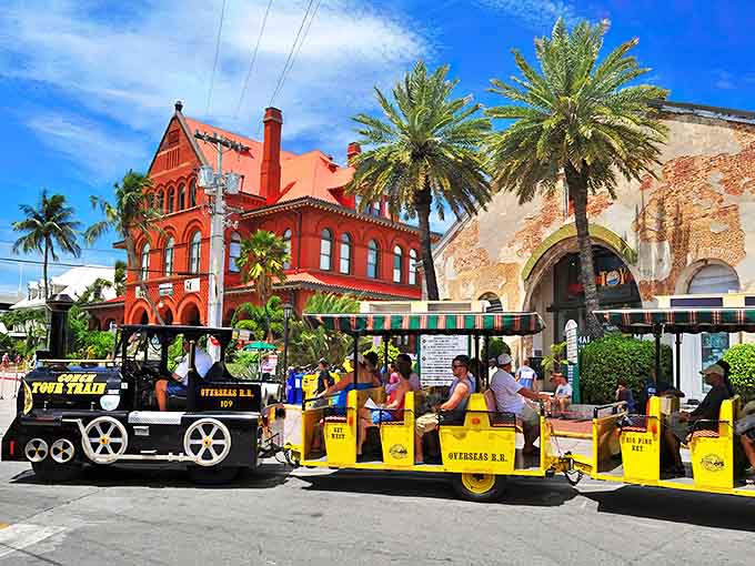 The iconic Conch Tour Train chugs past Key West's historic red brick Custom House, where island history meets tropical charm.