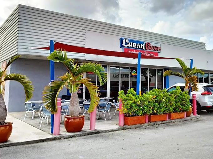The vibrant storefront of Cuban Guys beckons with its patriotic color scheme and promise of sandwich perfection. Palm trees frame this Miami treasure.
