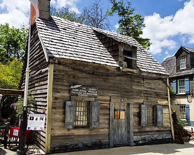 The weathered facade of America's oldest wooden schoolhouse stands defiantly against time, its hurricane chains ready for Florida's next big blow.