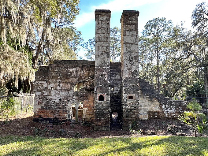 Twin stone chimneys reach skyward like ancient sentinels, their weathered faces telling tales of Florida's industrial past.