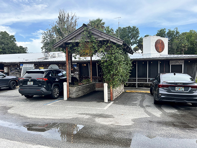 The rustic wooden entrance to The Yearling Restaurant beckons with vintage charm and a weathered "WE GIVE SOUTHERN STAMPS" sign &ndash; pure Old Florida nostalgia.