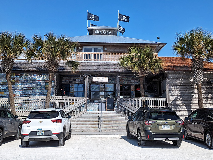 Pirate flags flutter above this weathered treasure chest of a restaurant, where palm trees stand guard and seafood adventures await.