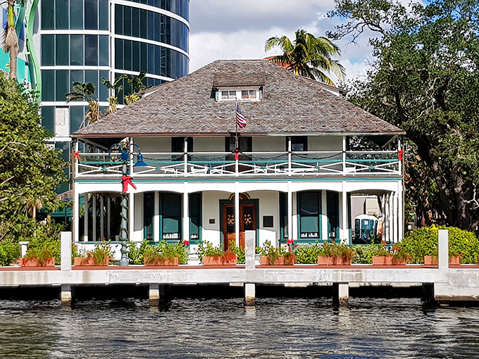 The Stranahan House stands proudly along the New River, a white wooden sentinel guarding Fort Lauderdale's past against the encroaching skyline.