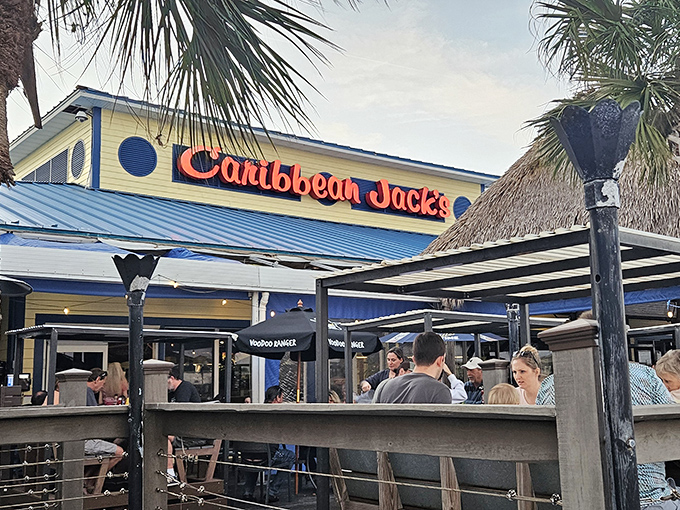 Caribbean Jack's sunny yellow exterior with vibrant blue trim welcomes visitors like a cheerful postcard from paradise come to life.