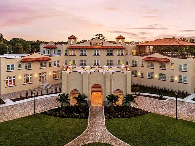 The Fenway Hotel stands majestically against a sunset sky, its Spanish-Mediterranean architecture a love letter to Florida's golden age.