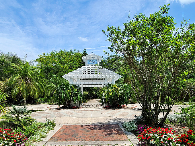 The elegant pavilion stands like a white sentinel among the greenery, inviting visitors to pause beneath its geometric perfection.