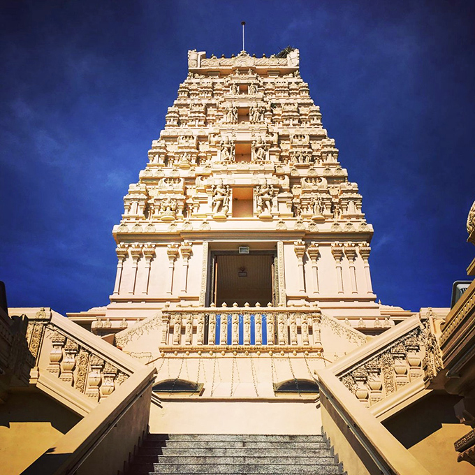 The Hindu Temple of Florida rises majestically against Tampa's blue sky, its ornate gopuram reaching heavenward like a divine exclamation point in the Florida landscape.