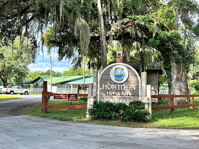 Welcome to paradise: Hontoon Island State Park's entrance sign stands beneath majestic oaks draped with Spanish moss, nature's own welcome committee.