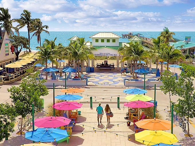 Lauderdale-by-the-Sea's vibrant plaza welcomes visitors with a rainbow of umbrellas and the promise of coastal relaxation just steps from the Atlantic.