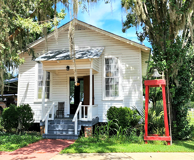 The charming white clapboard schoolhouse stands as a sentinel of history, Spanish moss draping from nearby oaks like nature's own decorations.