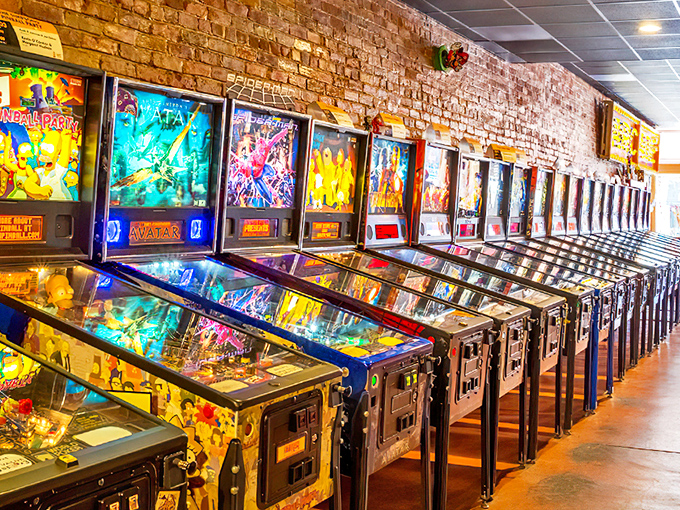 A rainbow of pinball machines stands at attention, each one a portal to a different world of flippers, bumpers, and that sweet, sweet multiball action.