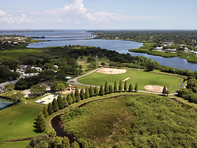 Sheffield Park from above: Nature's playground meets sports paradise in this aerial view, where baseball diamonds nestle against Florida's shimmering waterways.