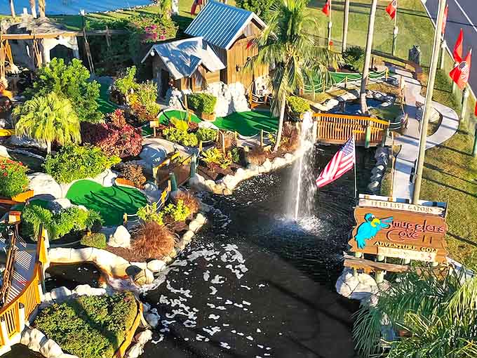 Aerial view of Smuggler's Cove reveals a pirate's paradise where waterfalls cascade alongside lush greenery and that iconic ship awaits adventurous putters.