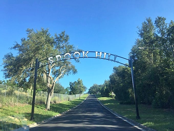 The iconic Spook Hill archway welcomes visitors to Florida's gravity-defying mystery spot, where cars seemingly roll uphill against all laws of physics.