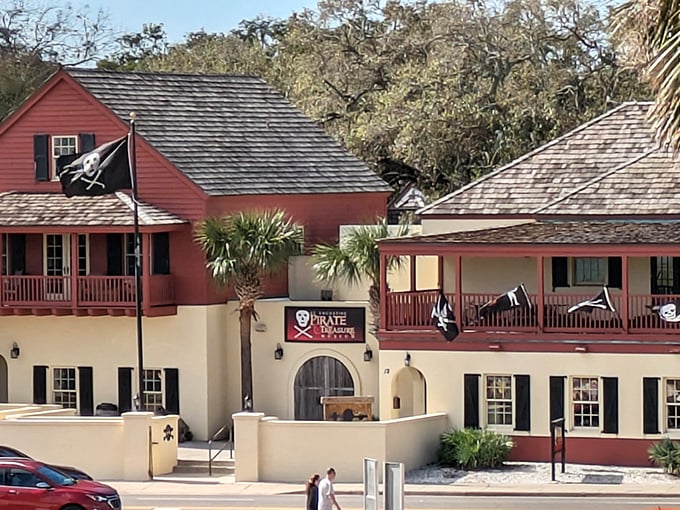 The crimson and cream fa&ccedil;ade of St. Augustine's Pirate Museum stands proudly against Florida's sky, pirate flags dancing in the breeze.