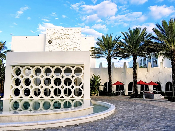 The striking modernist fa&ccedil;ade of The Wave Kitchen and Bar stands like a white beacon against Florida's blue sky, circular cutouts creating a mesmerizing pattern.