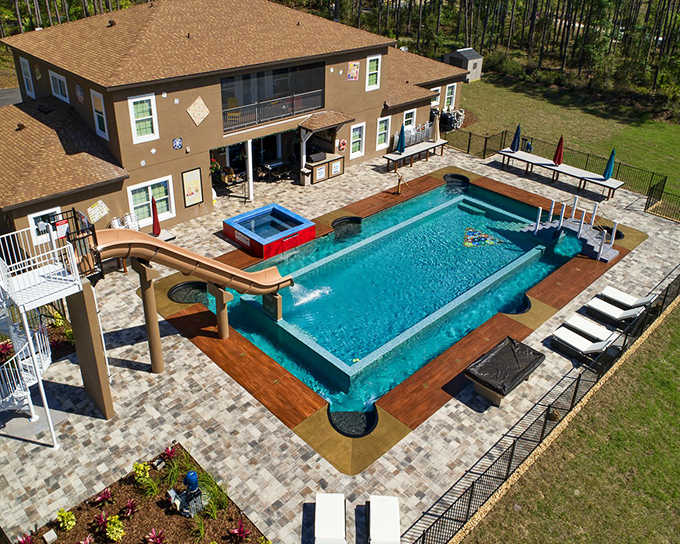 The Great Escape Lakeside's exterior showcases its impressive scale, with a resort-style pool that practically screams "cannonball opportunity!" surrounded by Florida's towering pines.