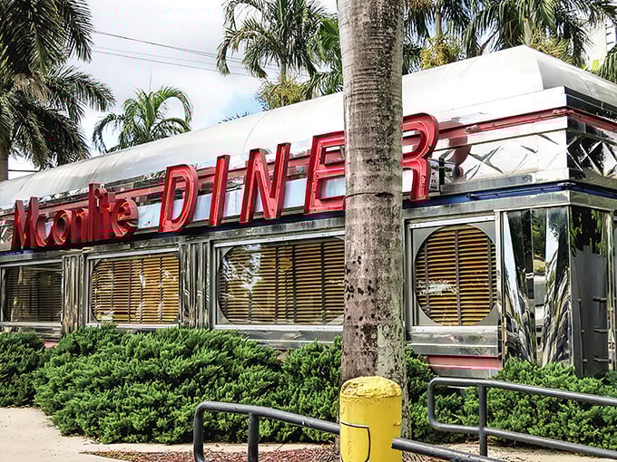 The gleaming silver exterior of Moonlite Diner stands like a chrome time machine amid swaying palm trees, beckoning hungry time travelers with its iconic red signage.