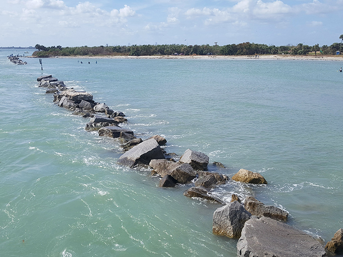 Sebastian's rocky jetty stretches into turquoise waters, nature's perfect dividing line between civilization and wild ocean currents.