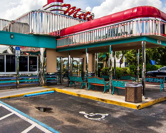The gleaming chrome exterior of Mel's Diner shines like a beacon of nostalgia, its vibrant red signage promising comfort food that transcends time.