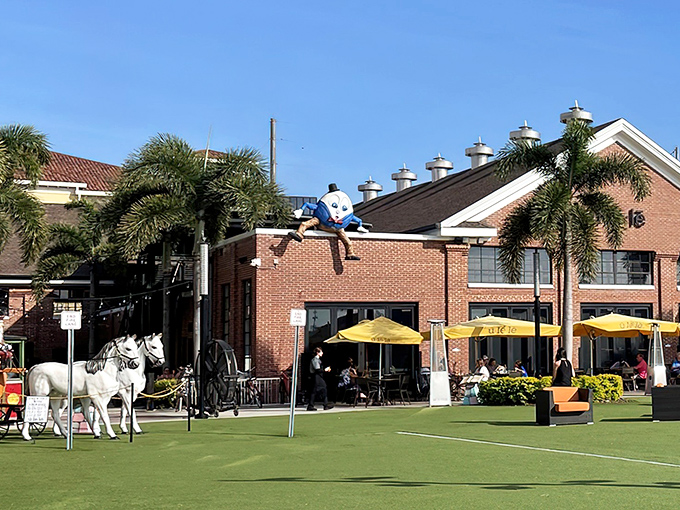 Ulele's enchanting exterior welcomes visitors with whimsical sculptures and bright yellow umbrellas, creating a storybook setting along Tampa's Hillsborough River.