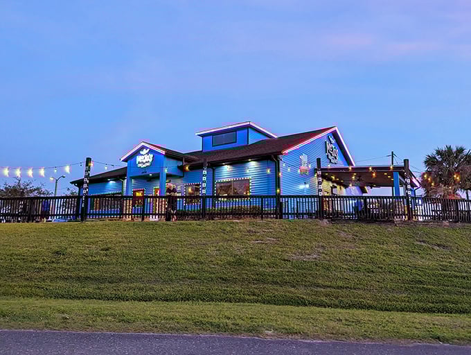 The bright blue building with red trim glows at dusk, promising a dining experience that's anything but ordinary. Musical magic awaits inside!