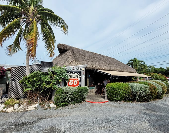 A slice of Old Florida awaits under this thatched roof, where the Phillips 66 sign promises fuel for both vehicles and appetites.